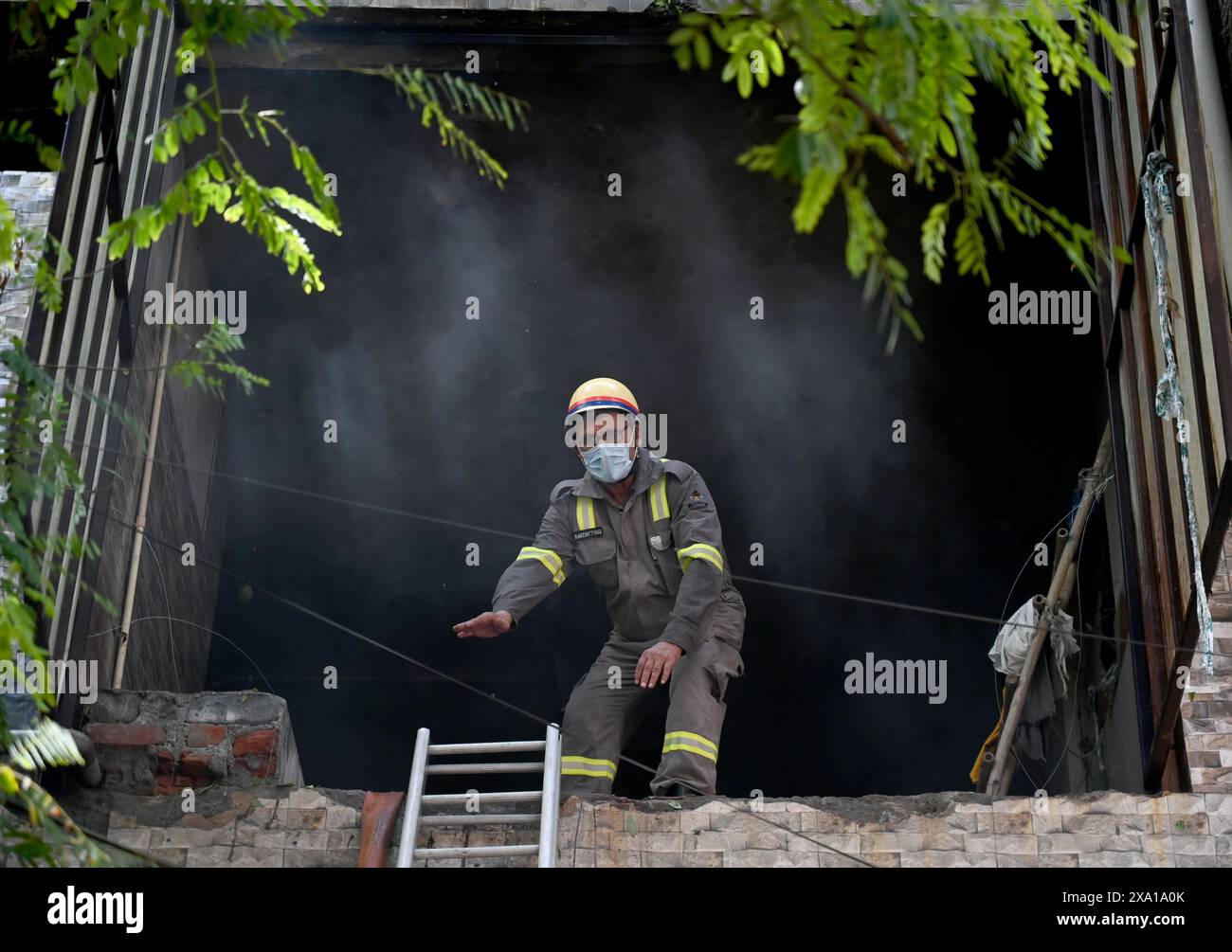 NOIDA, INDIA - JUNE 3: Fire brigade personnel extinguish the fire at a garment factory in Sector ...