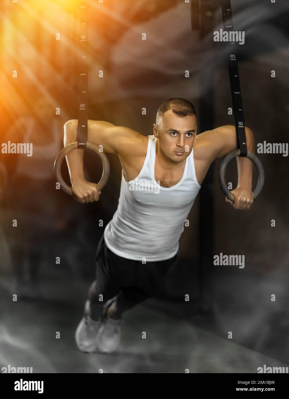 Stylized shot of athlete performing chest push-ups on gymnastic rings ...