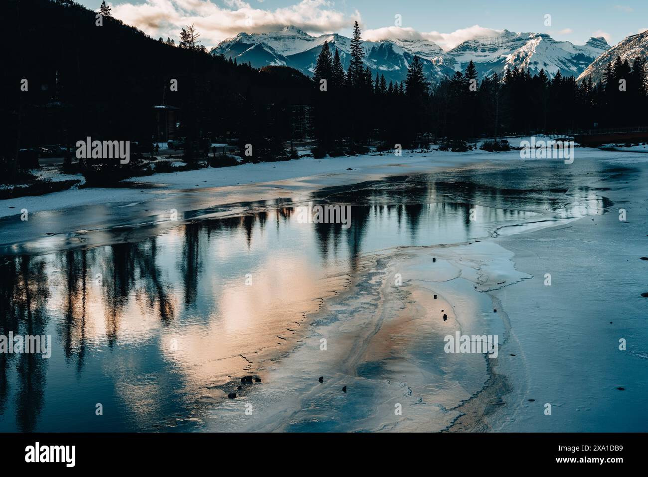 A reflection of snowy mountains on a serene lake surface Stock Photo ...