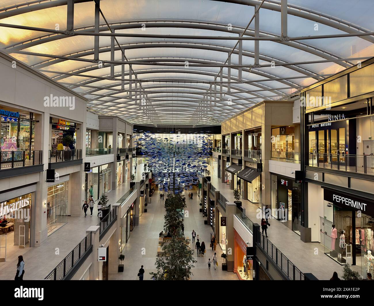 The busy shopping mall with various stores and shoppers browsing ...