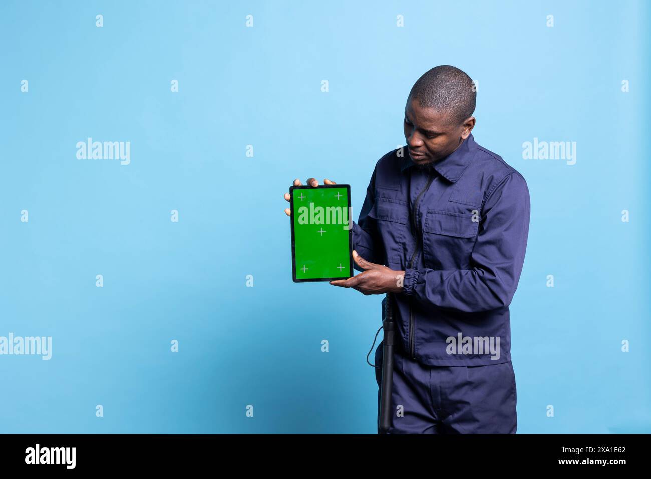 Trained armed bodyguard holds a tablet with greenscreen layout on ...