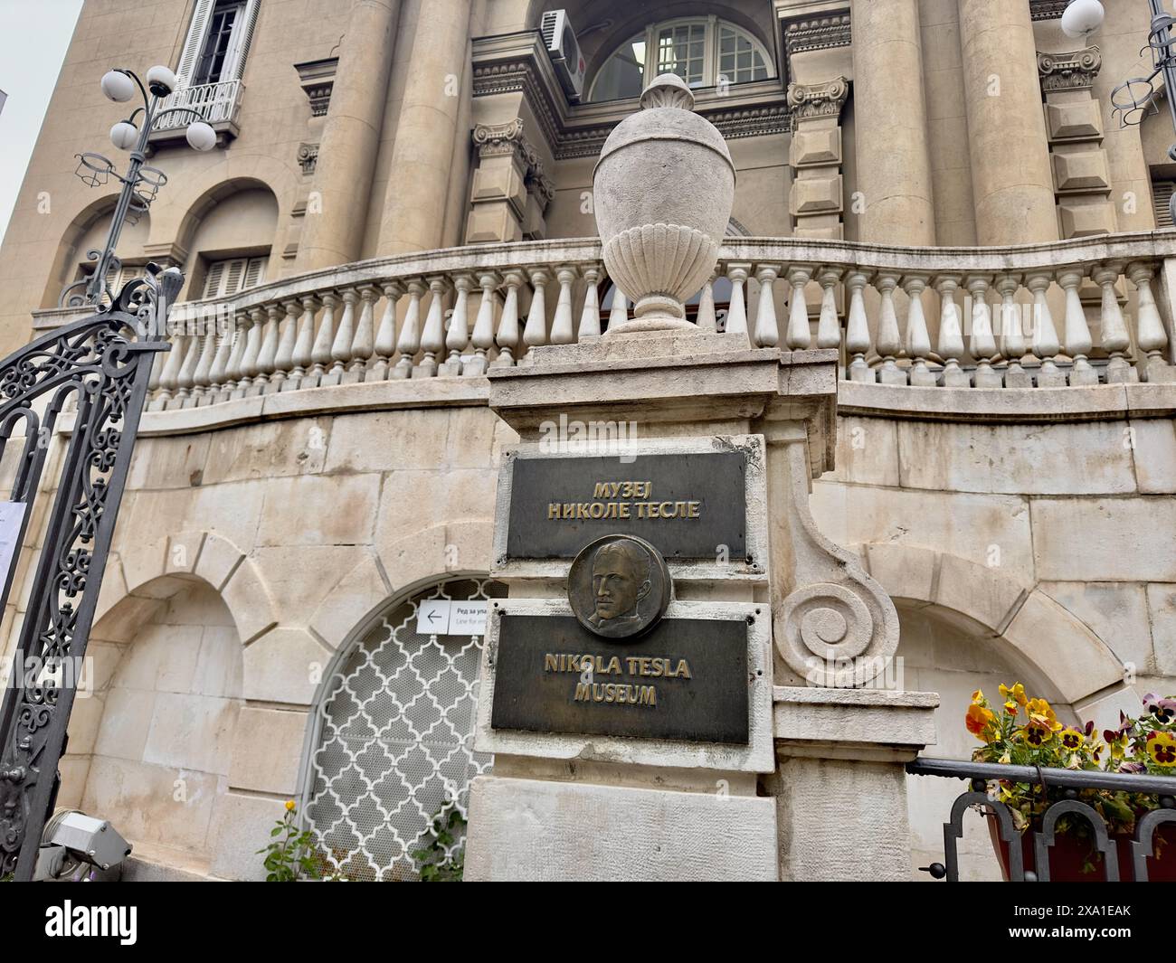 A massive stone clock tower on the side of a building in Nikola Tesla ...