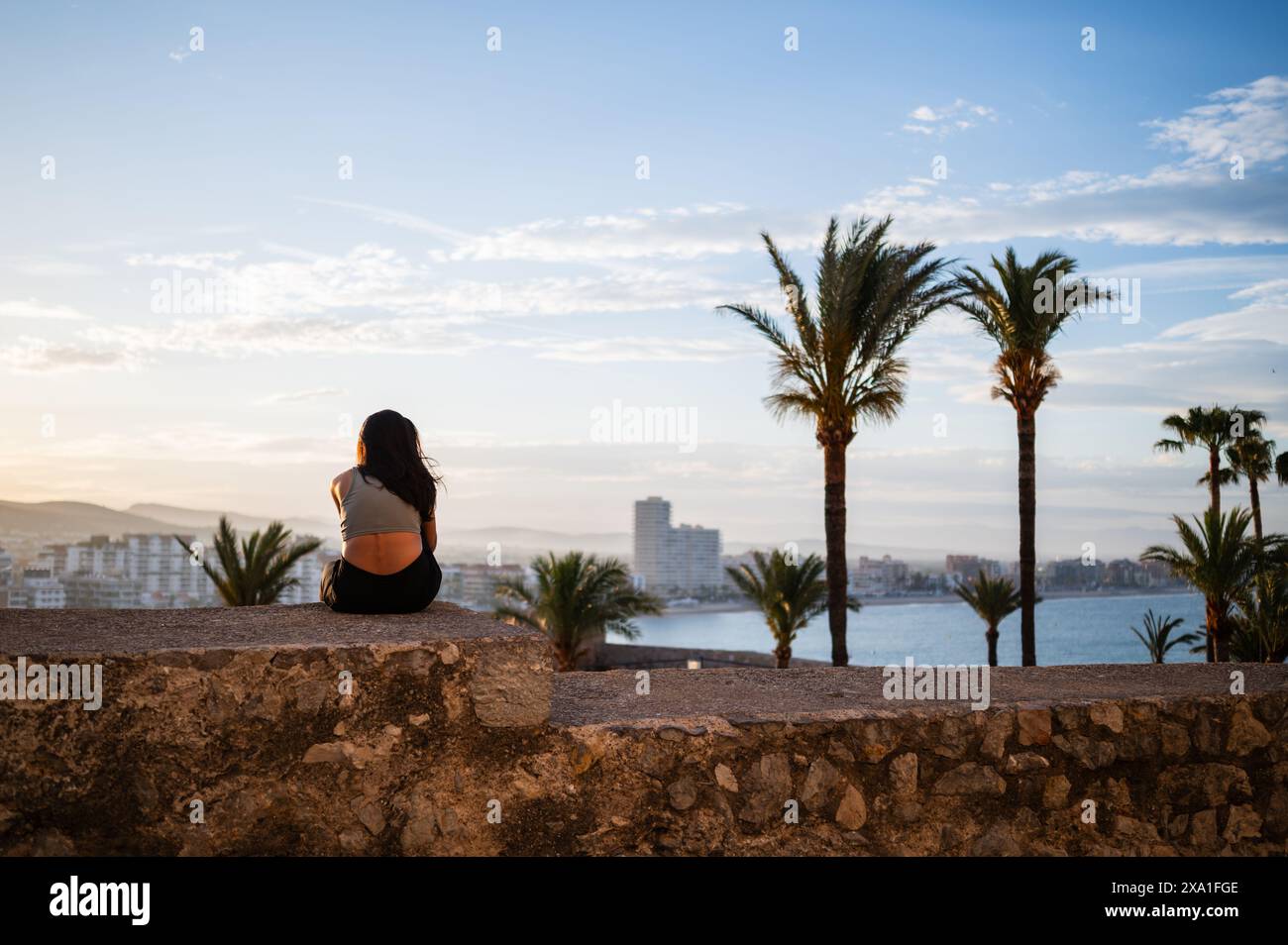 Young woman enjoying the sunset from the city walls of Papa Luna castle ...