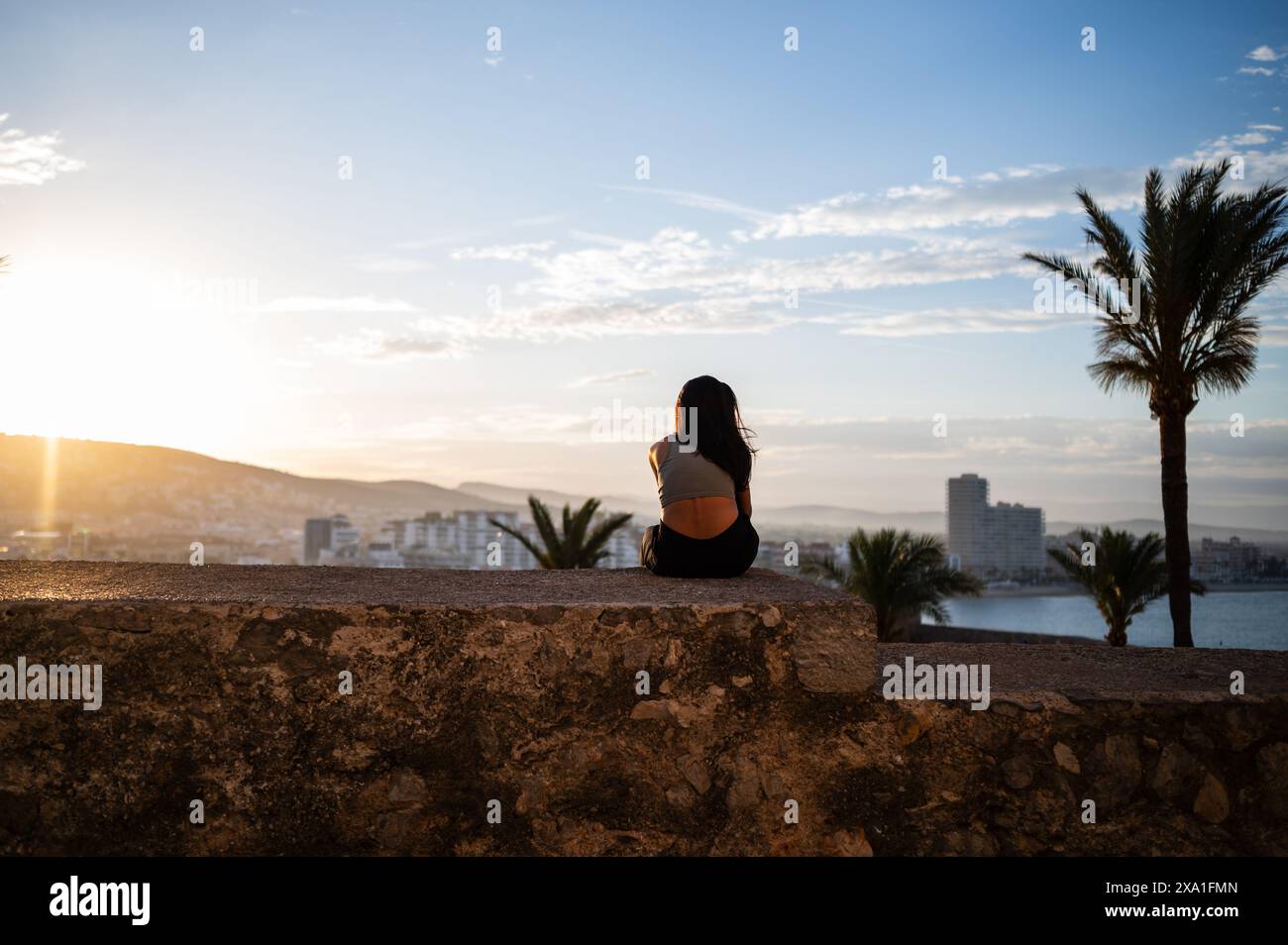Young woman enjoying the sunset from the city walls of Papa Luna castle ...