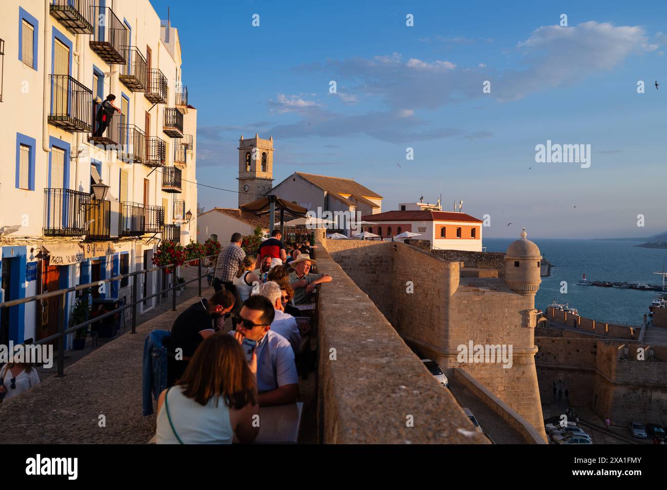 Visitors enjoying the sunset from a restaurant on the city walls of the ...