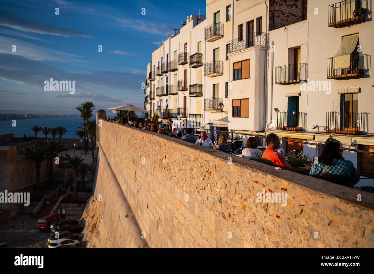 Visitors enjoying the sunset from a restaurant on the city walls of the ...