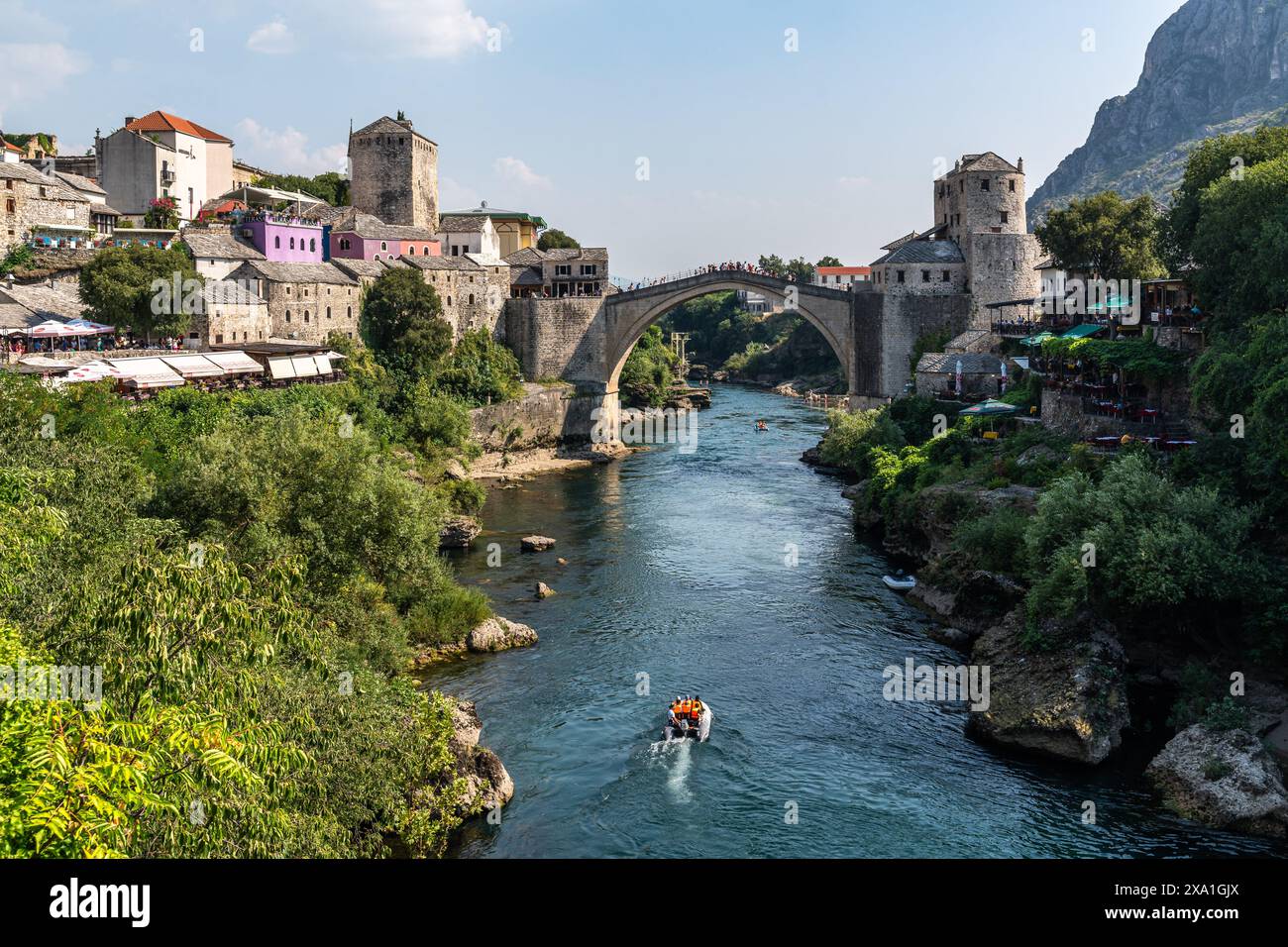 This photo captures a river running through Mostar city, with a ...
