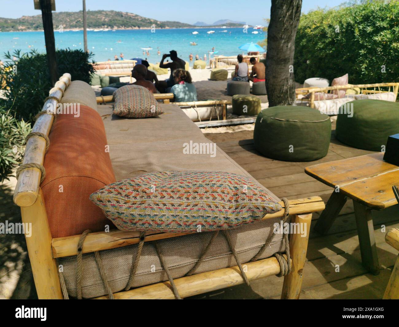 A beachfront outdoor seating area with guests enjoying the beach view ...