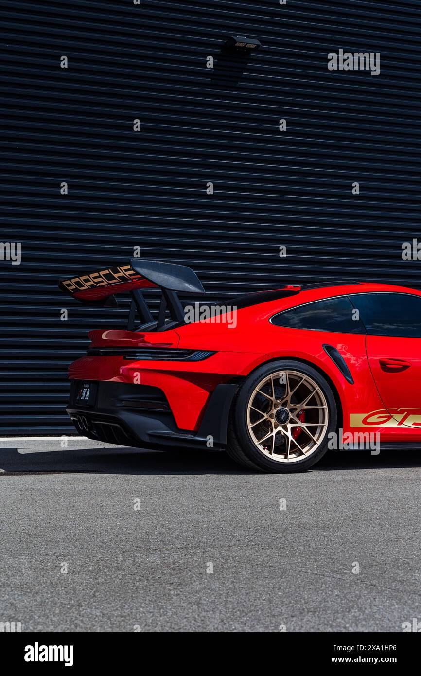 A Guards Red 992 Porsche GT3 RS with Aurum Gold wheels on a road Stock ...