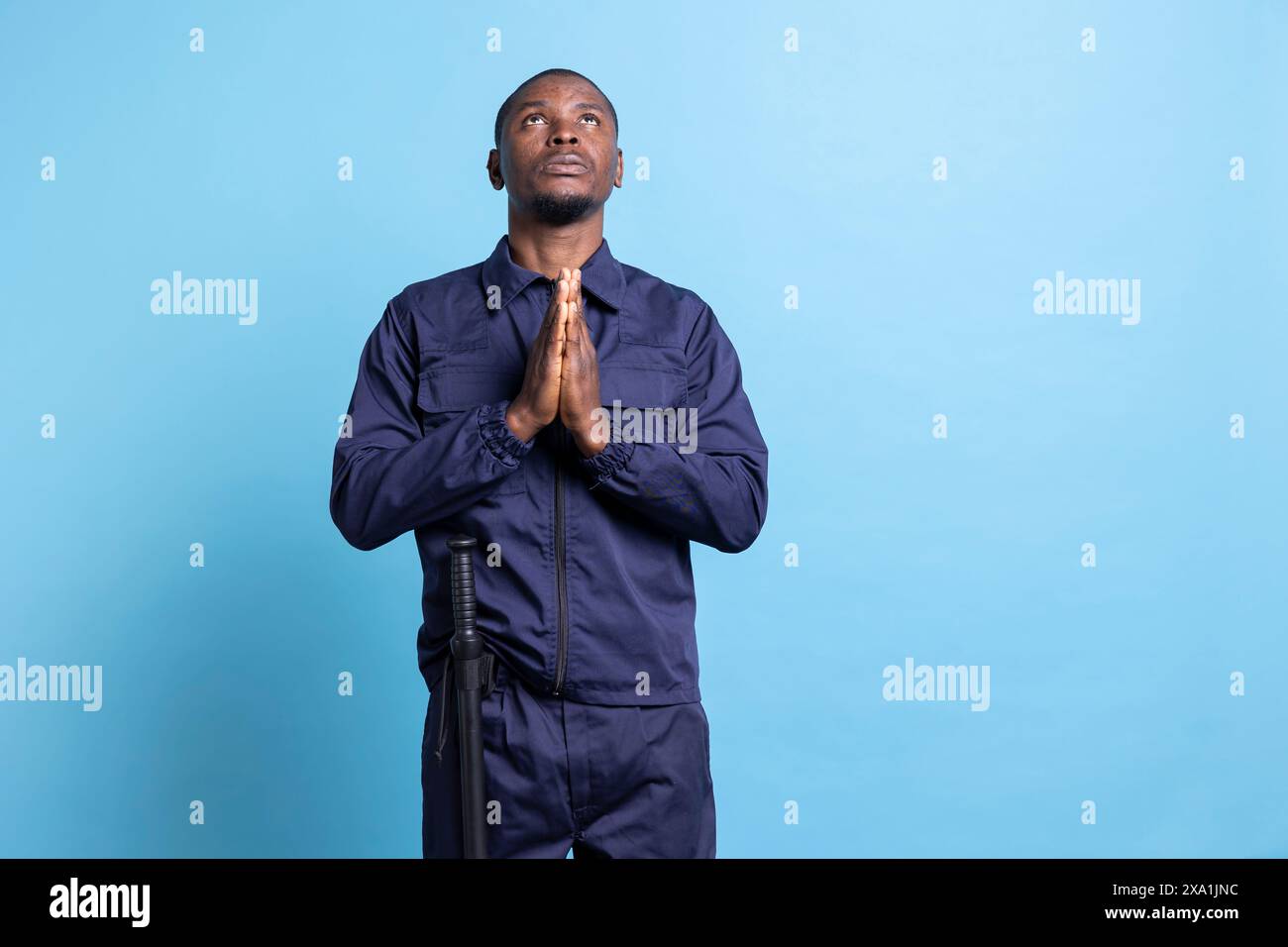 Religious security agent praying to God and having faith against blue ...