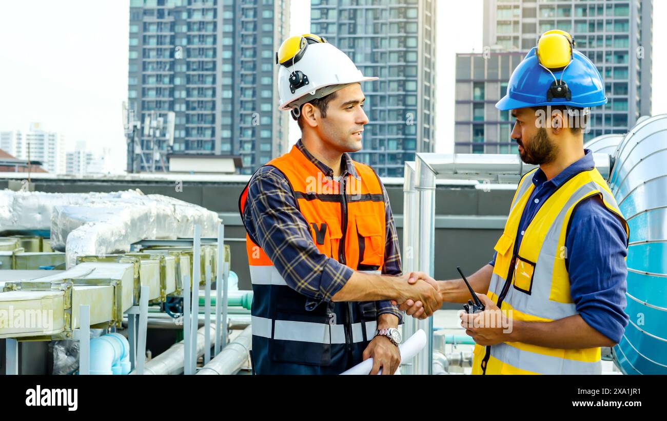The two construction workers discussing and shaking hands over building ...