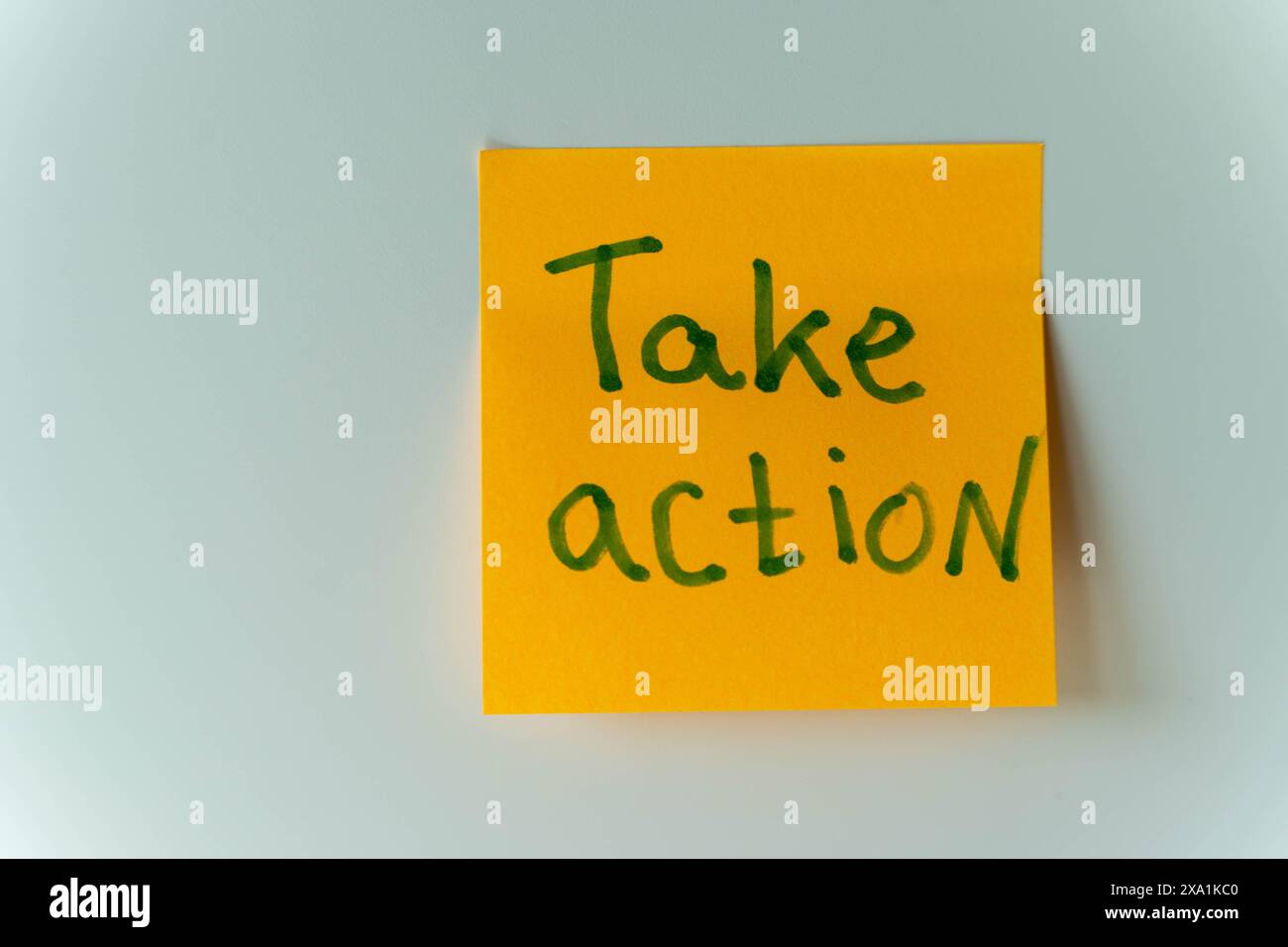 A yellow reminder sticker with the message Take action written in green ...