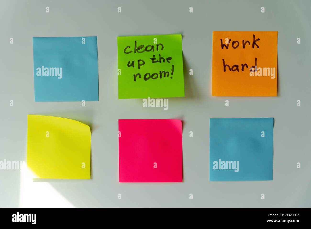 Six colorful sticky notes with handwritten reminders on a white surface ...