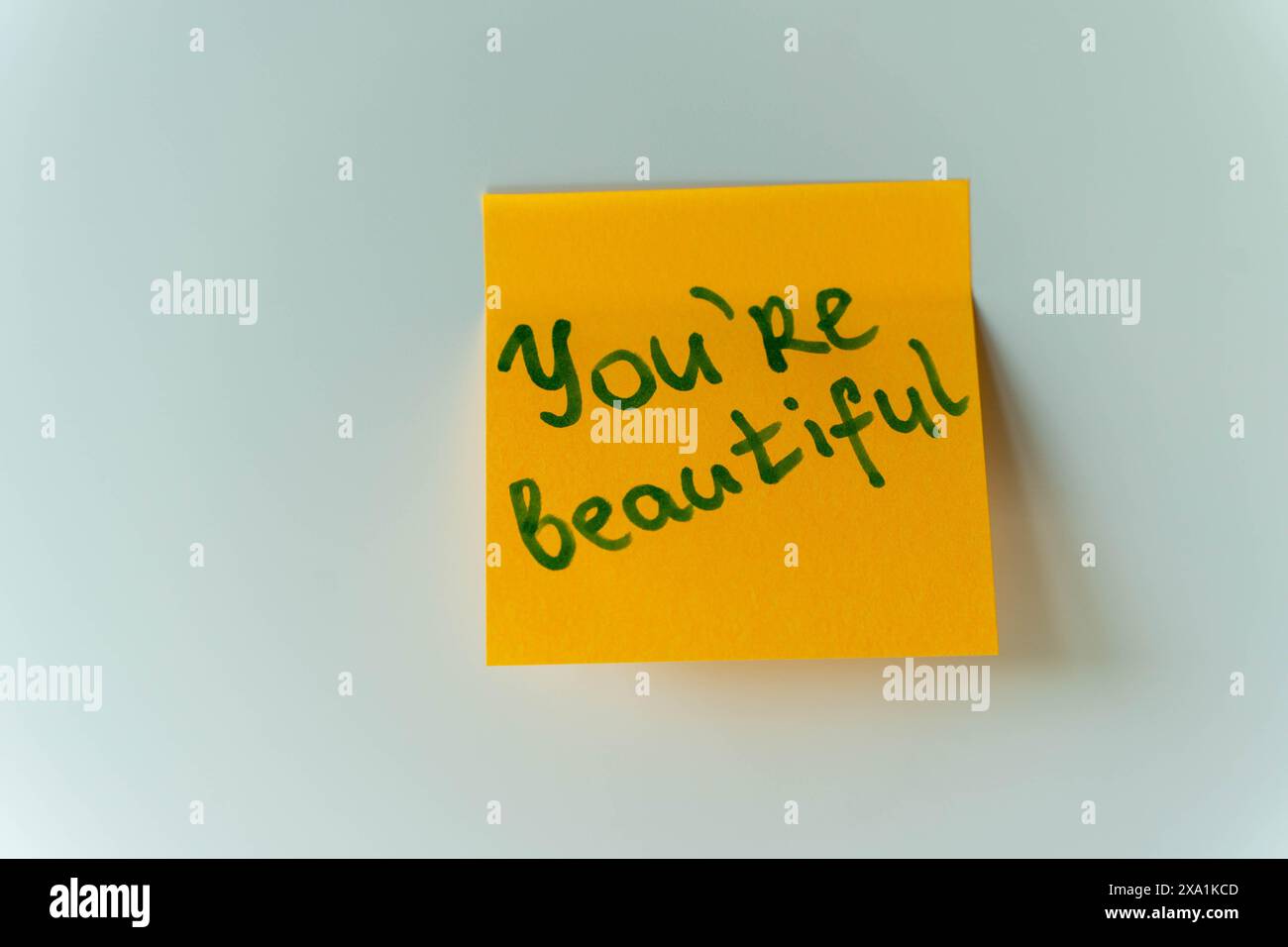 A yellow post-it note with green handwritten text, Youre beautiful, is ...