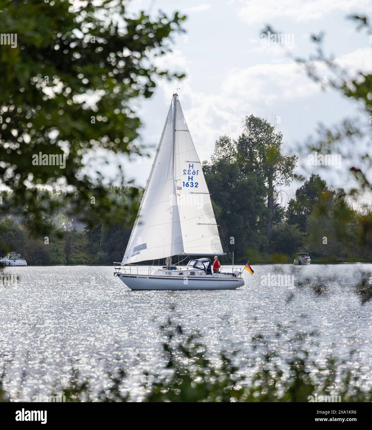 A small boat sails on a vast body of water under cloudy skies Stock ...