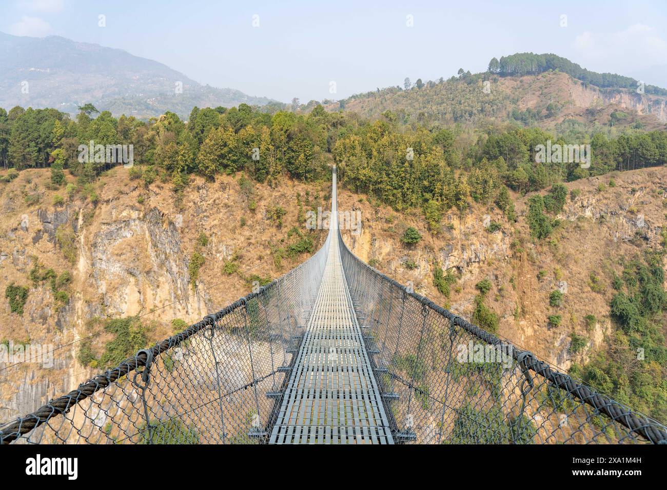 A suspension bridge over a canyon in the mountains of Nepal Stock Photo ...