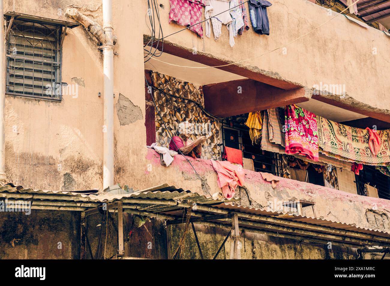 A woman standing on a balcony of a historic building in Mumbai, India ...
