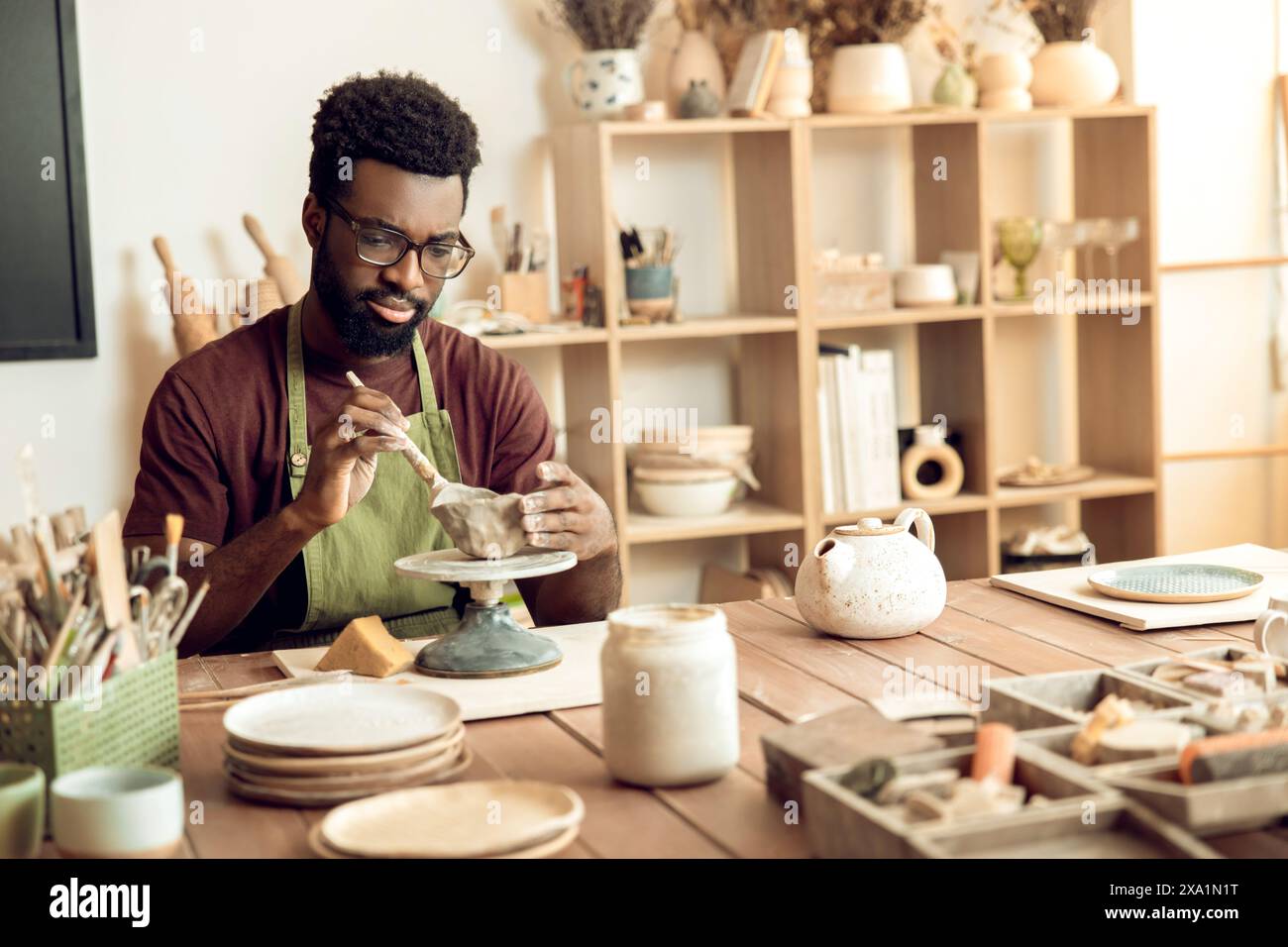 Professional working in a pottery studio on creation of a new product ...