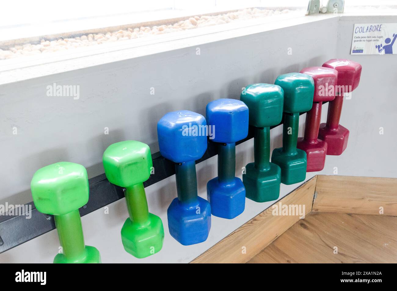 Various colored dumbbells and weights on showcase Stock Photo - Alamy