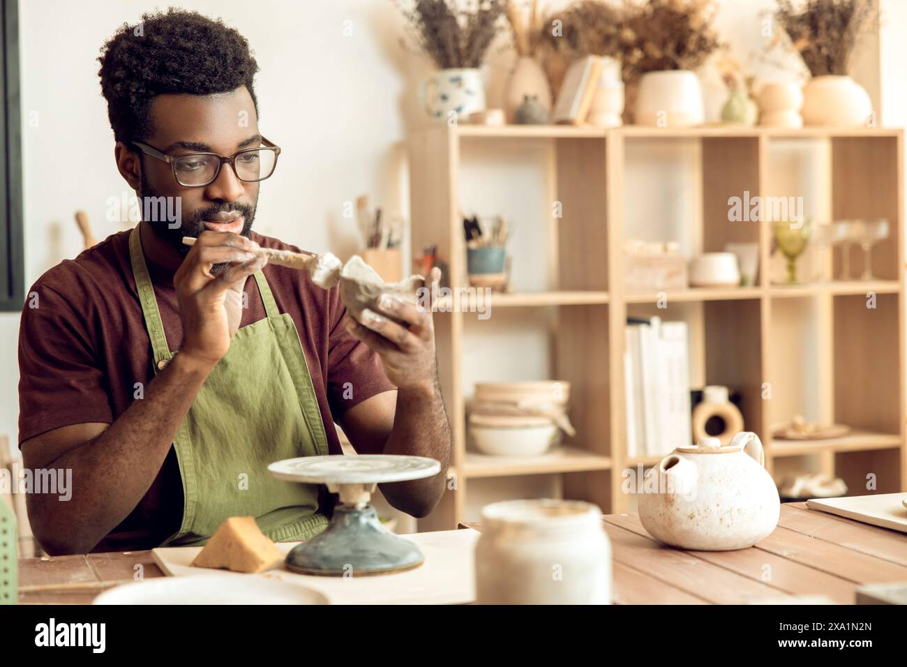Professional working in a pottery studio on creation of a new product ...