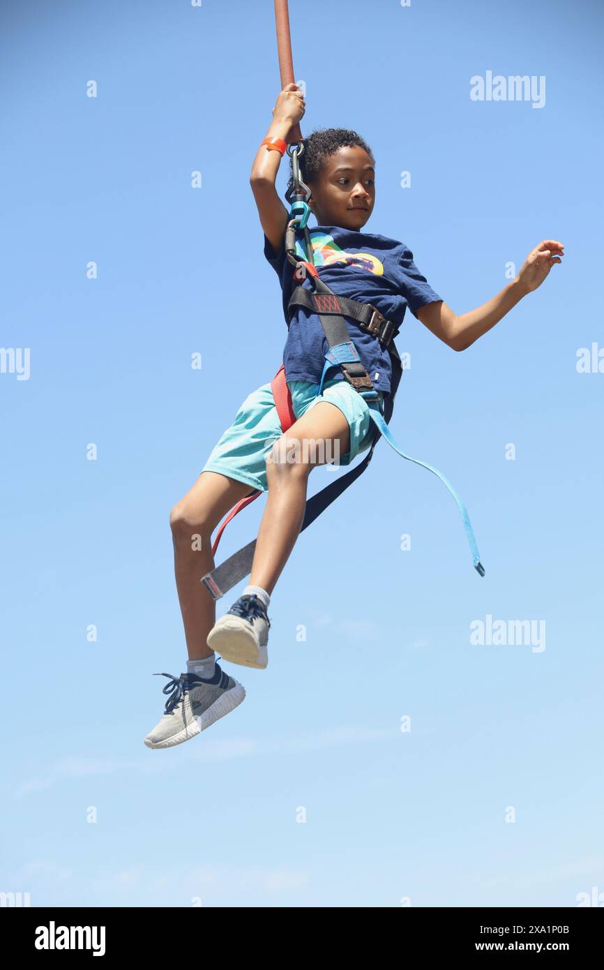 A young person swinging on a rope in the sky with a red line Stock ...