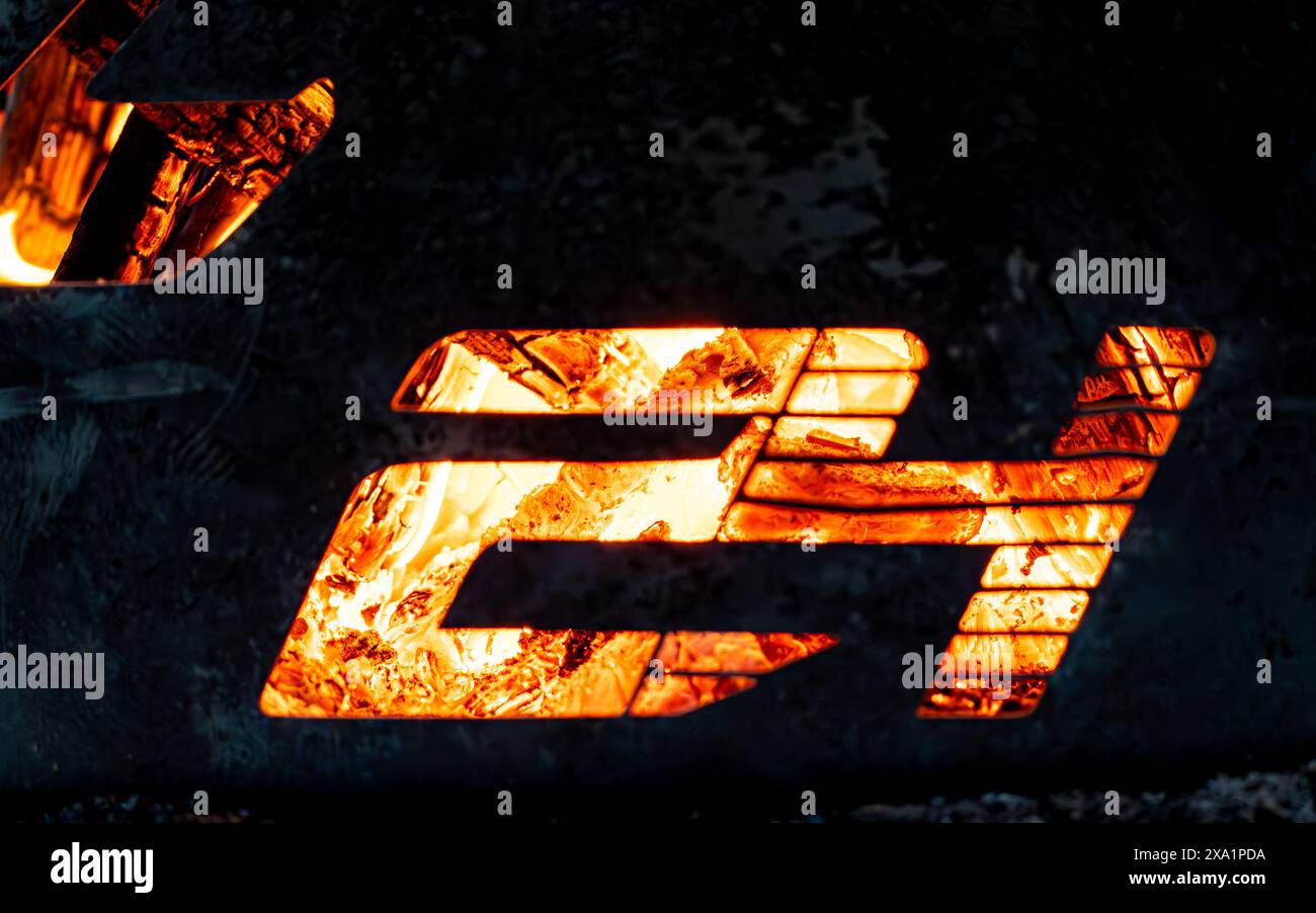 Close up of the glowing fire behind a 24 shaped cut out in the metal ...