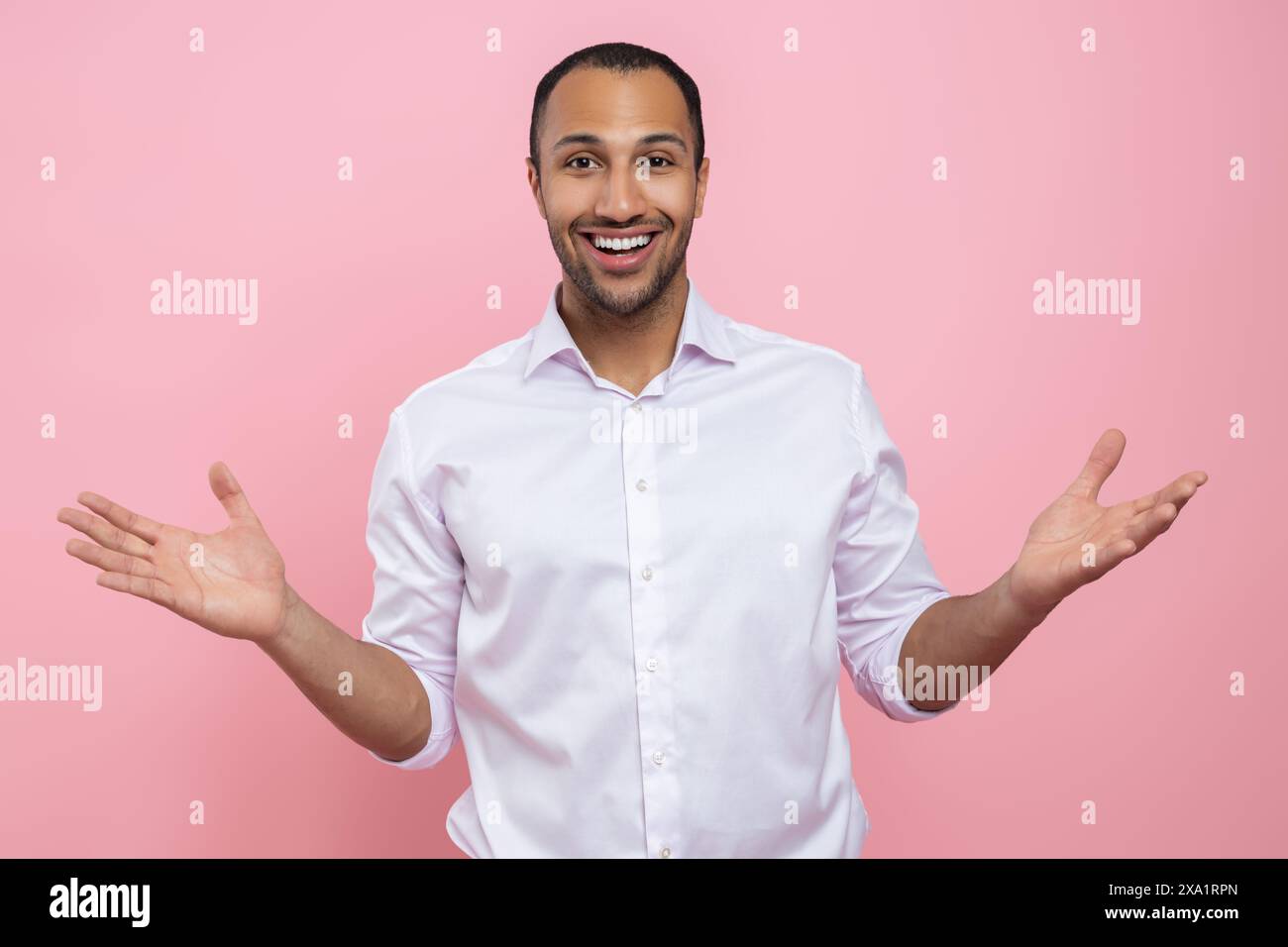 Surprised man in white shirt showing welcome gesture Stock Photo - Alamy