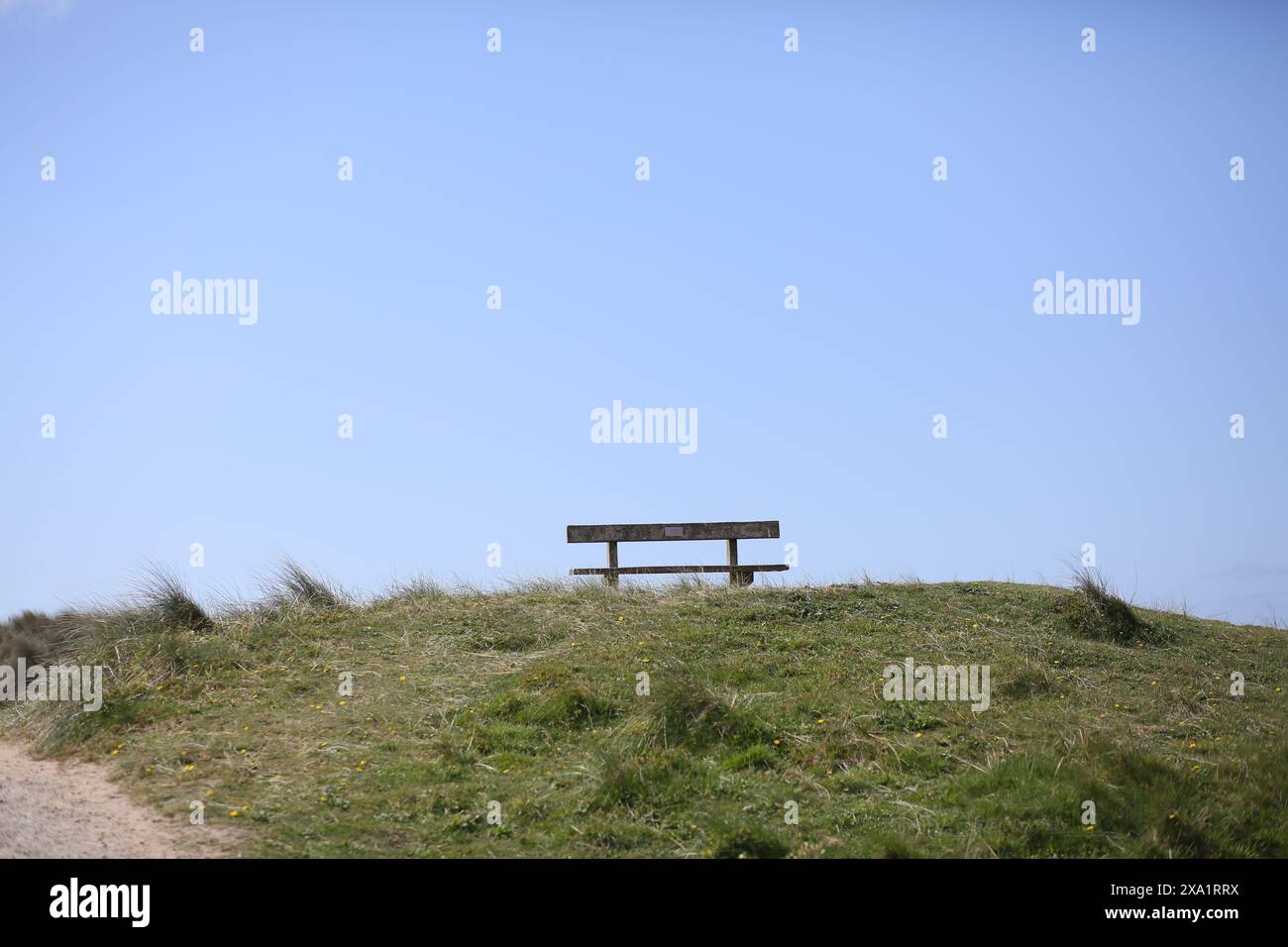 A bench on a hill overlooking a grassy field below Stock Photo - Alamy