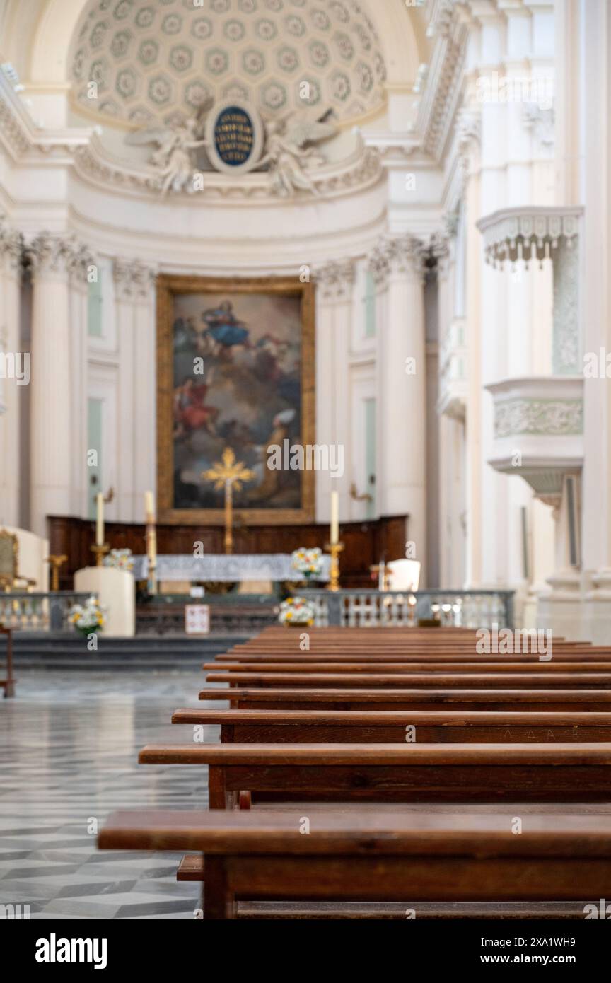 Front view of the Urbino church with benches and a painting above them ...