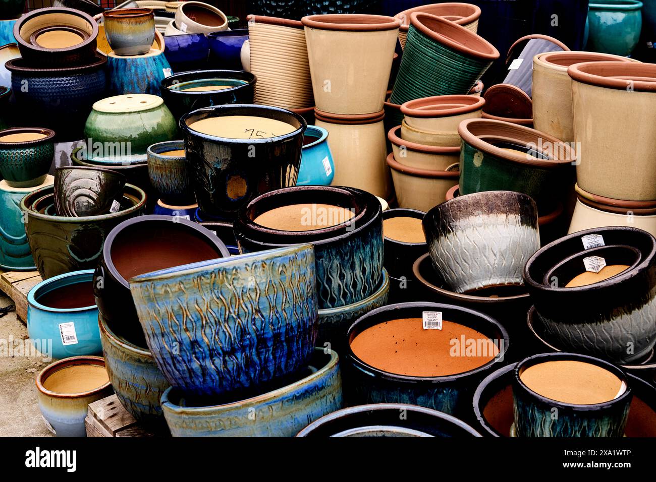 Stacks of different colorful plant pots for sale at a local garden ...