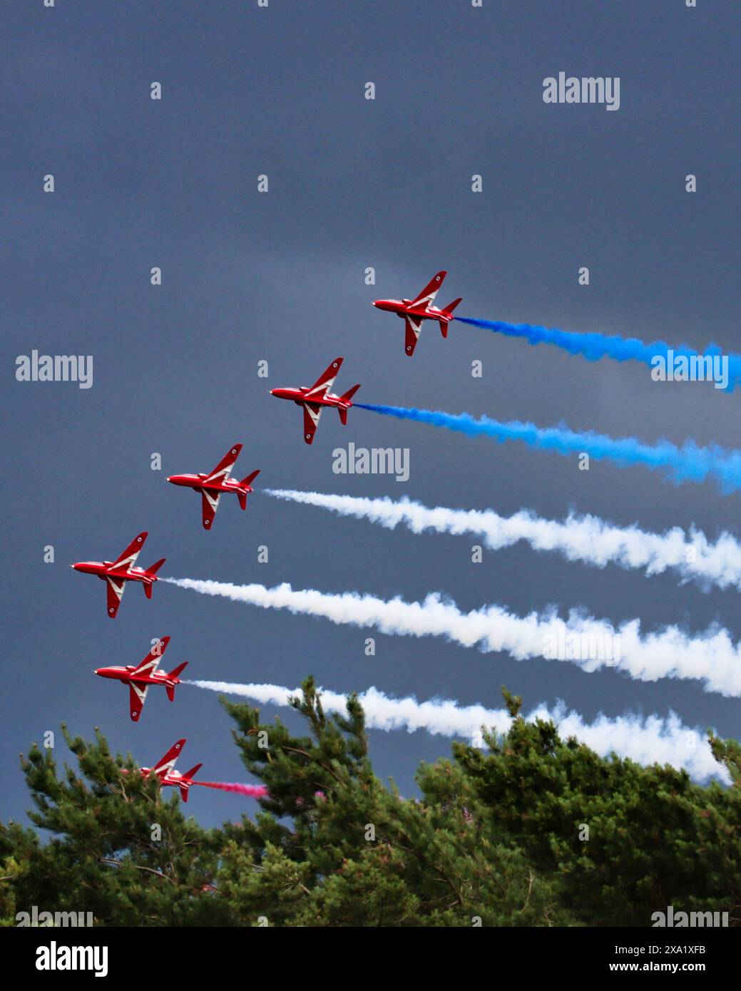 The Red Arrows jets flying in formation above a row of trees Stock ...