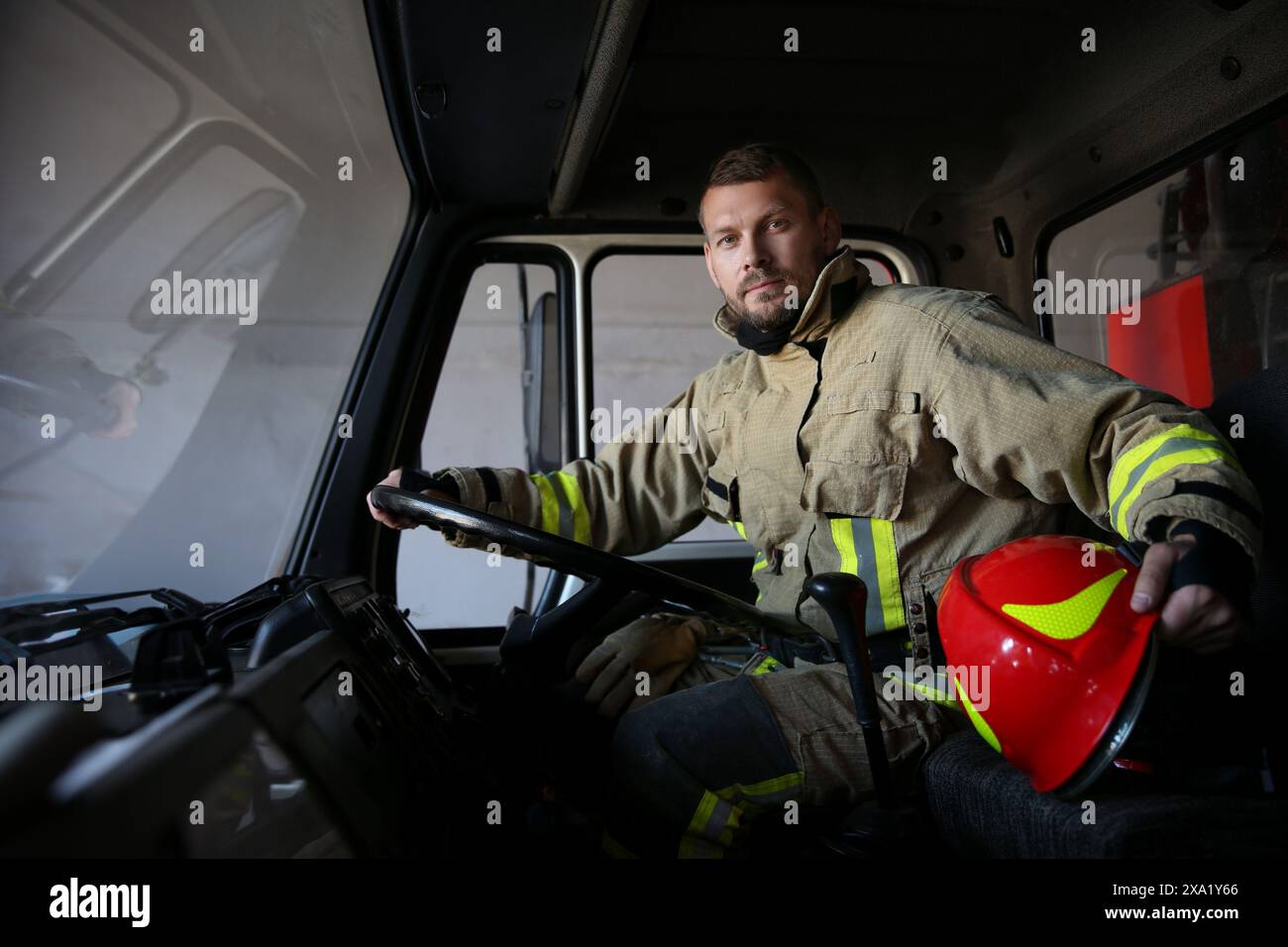 Firefighter in uniform with helmet driving modern fire truck Stock ...