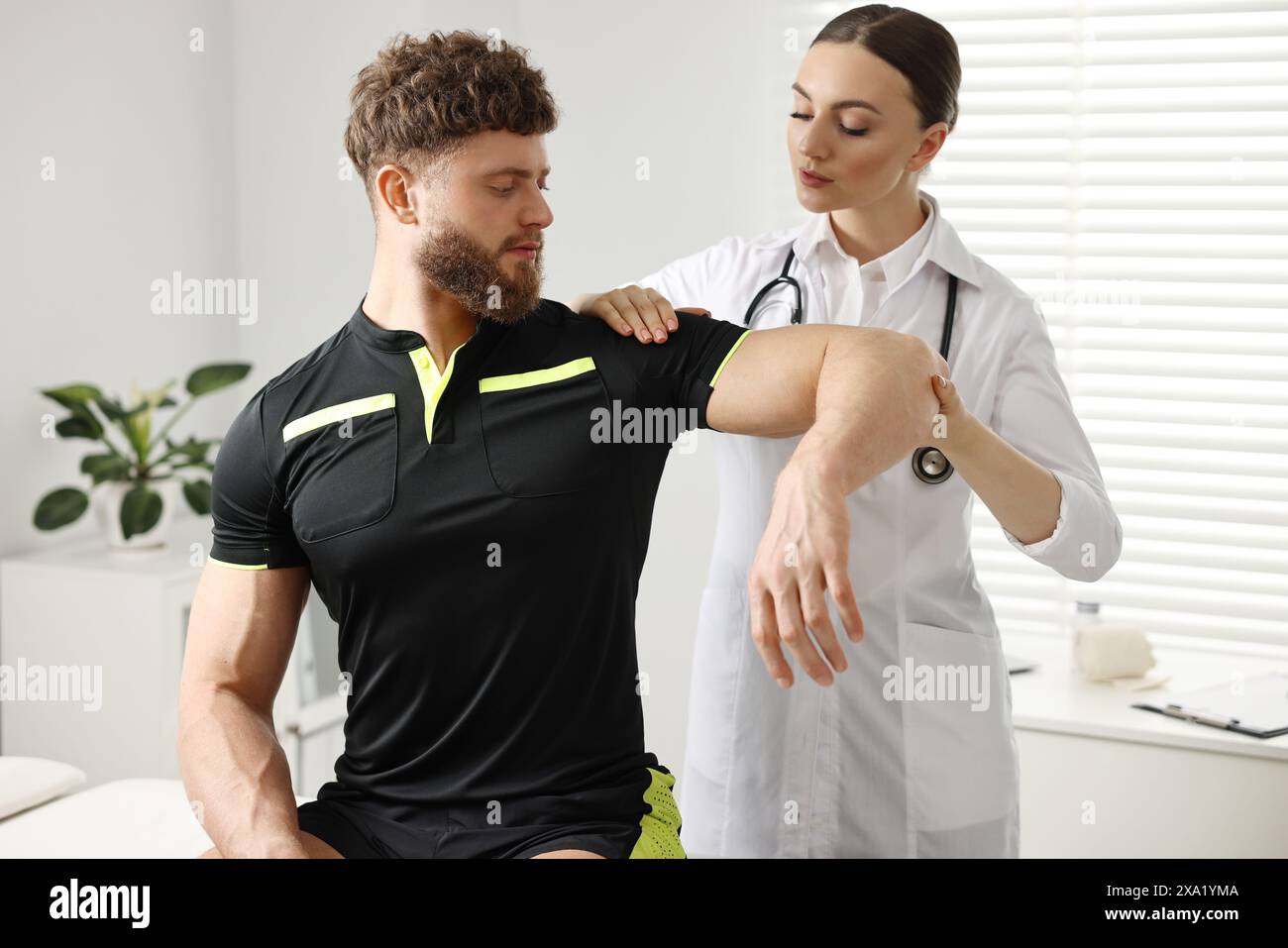 Sports injury. Doctor examining patient's shoulder in hospital Stock ...