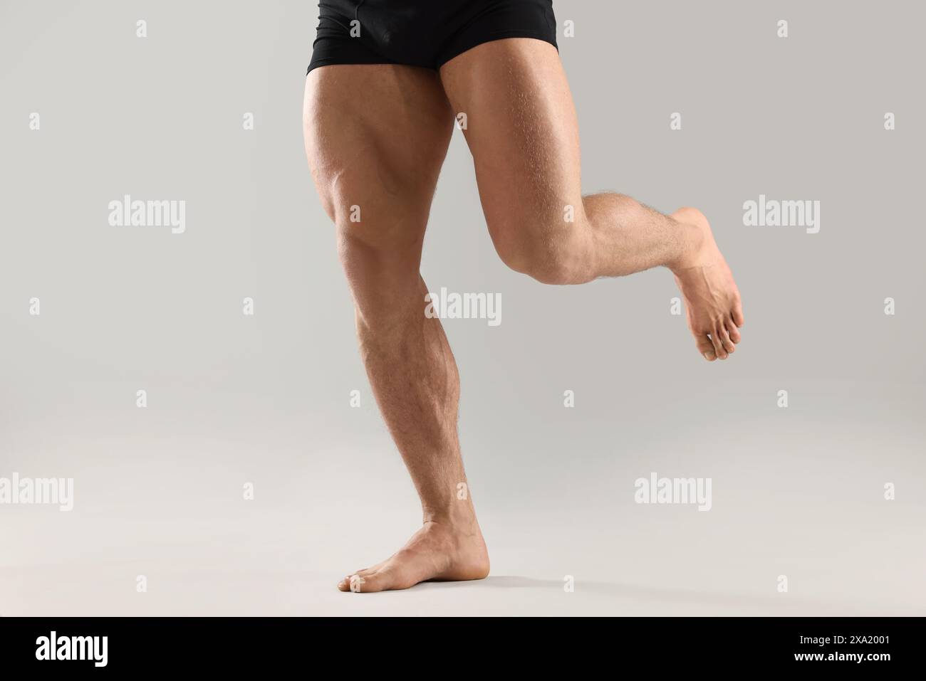 Man with muscular legs on light grey background, closeup Stock Photo ...
