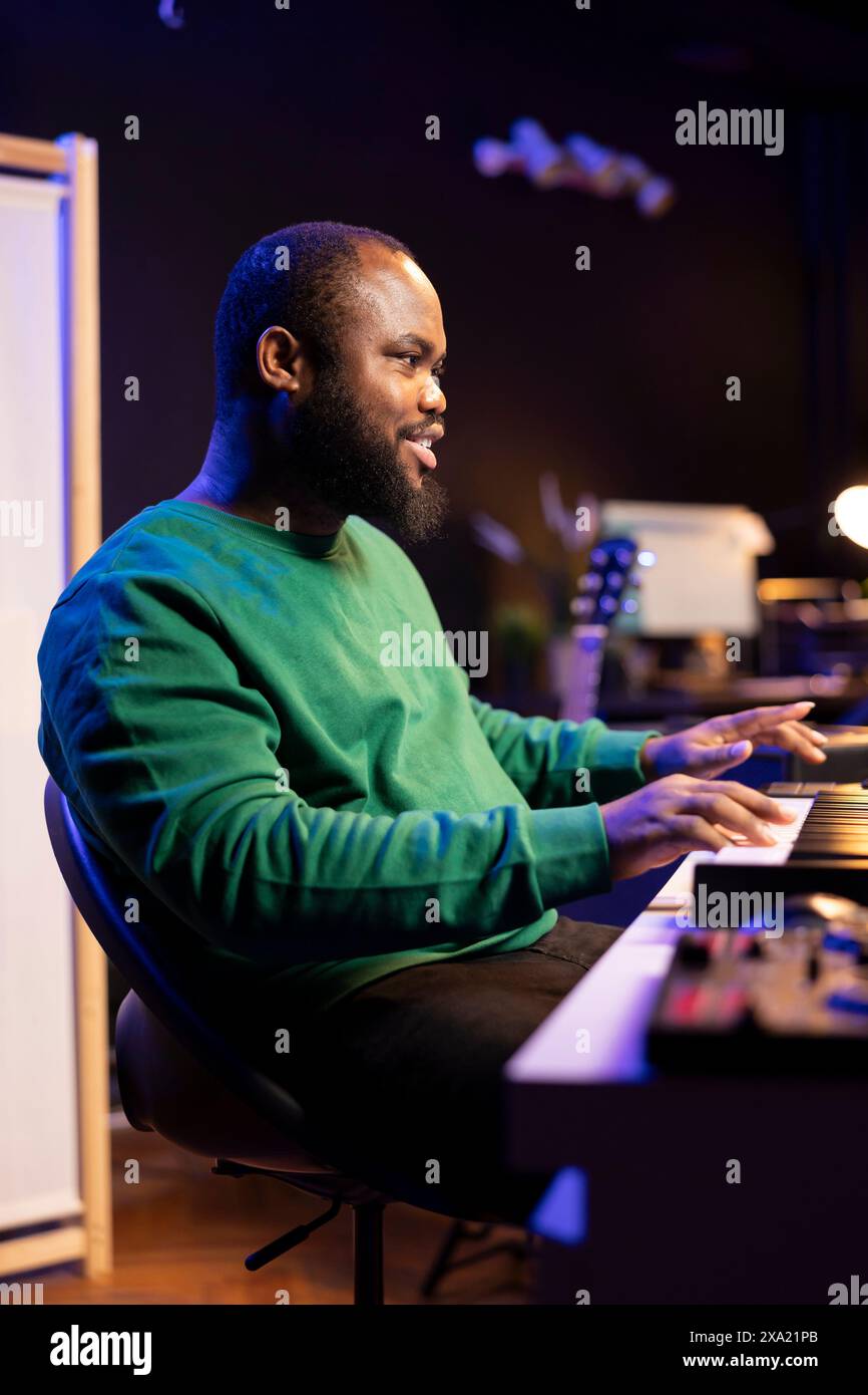 Artist playing piano electronic keyboard and recording new sounds ...