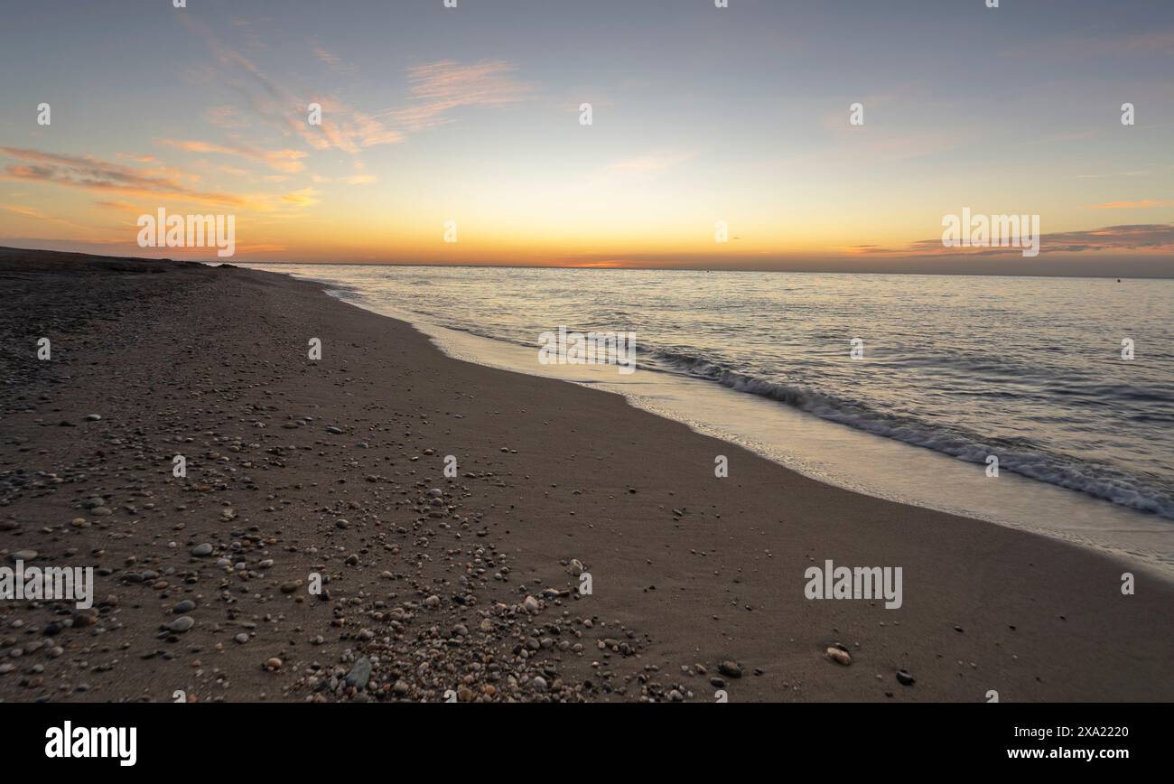beach lies empty, beneath a sky awash in breathtaking shades of orange ...