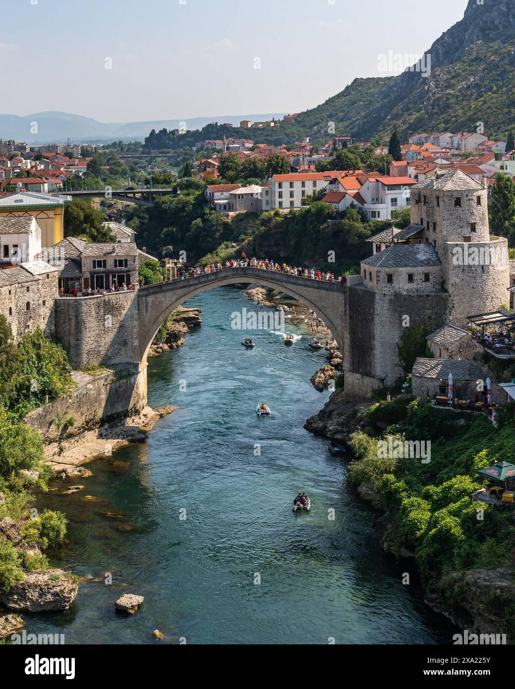 This photo captures a river running through Mostar city, with a ...
