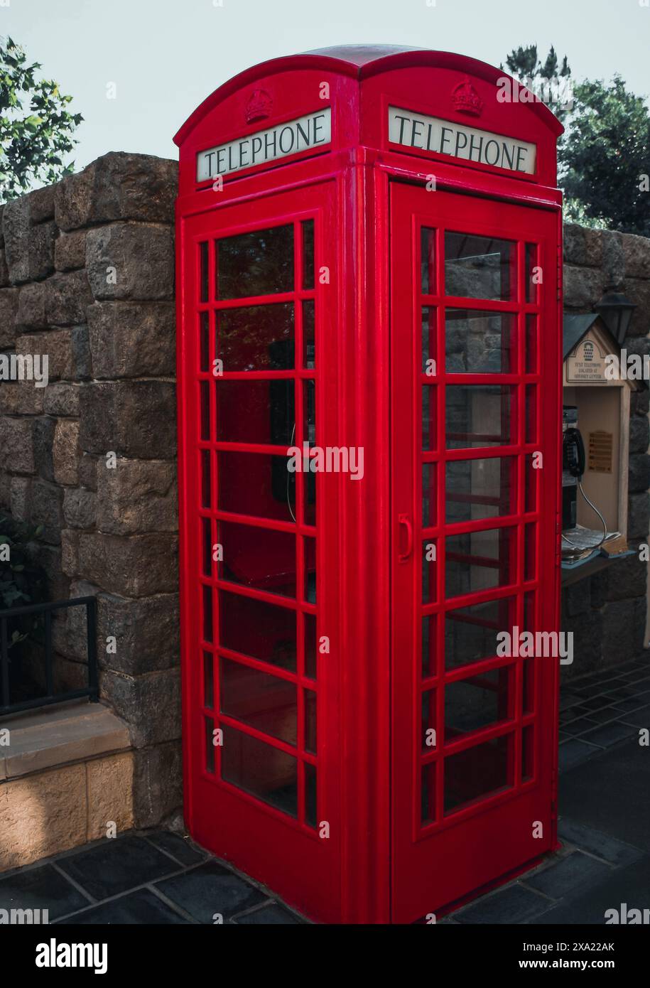 A classic red telephone booth near stone wall and gate Stock Photo - Alamy