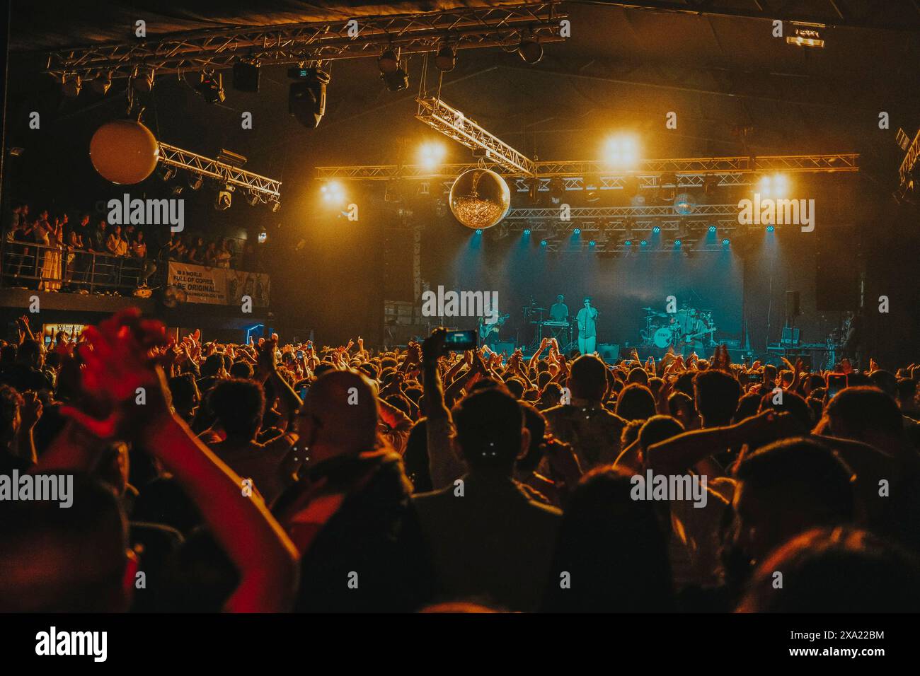 A nighttime concert scene with a crowd of spectators enjoying the show ...