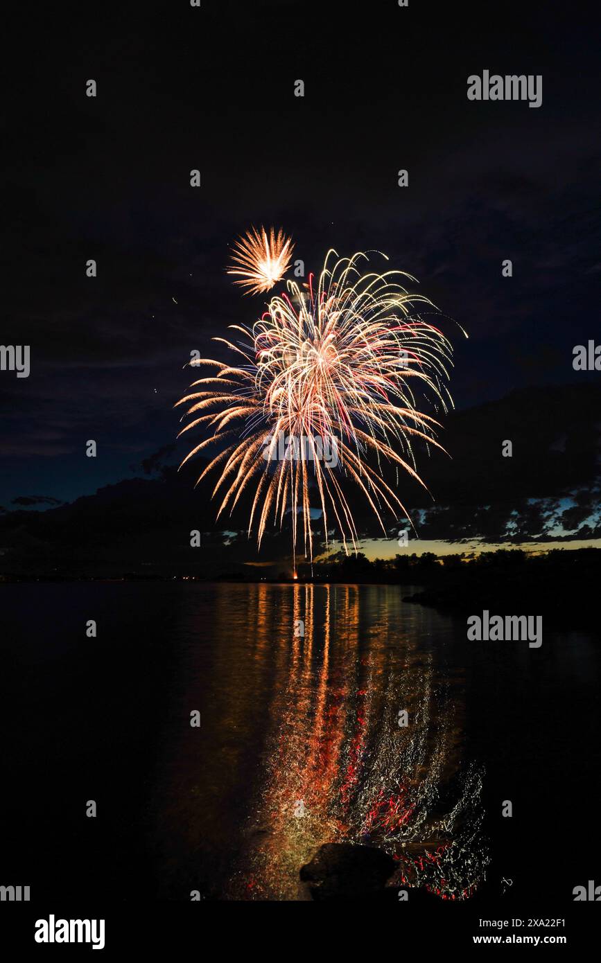 Fireworks lighting up the night sky over water Stock Photo - Alamy