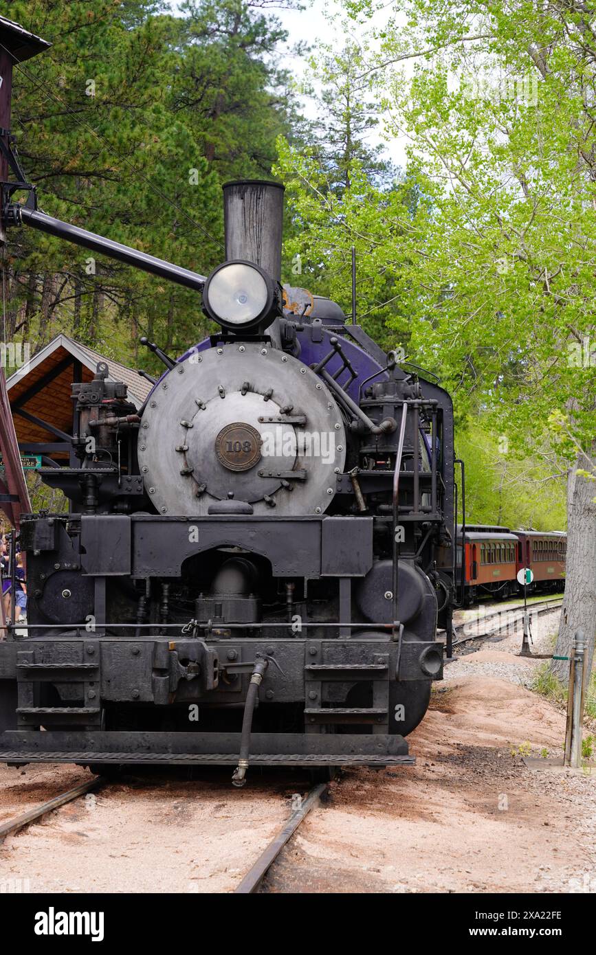 A man poses by a vintage train engine on railway tracks Stock Photo - Alamy