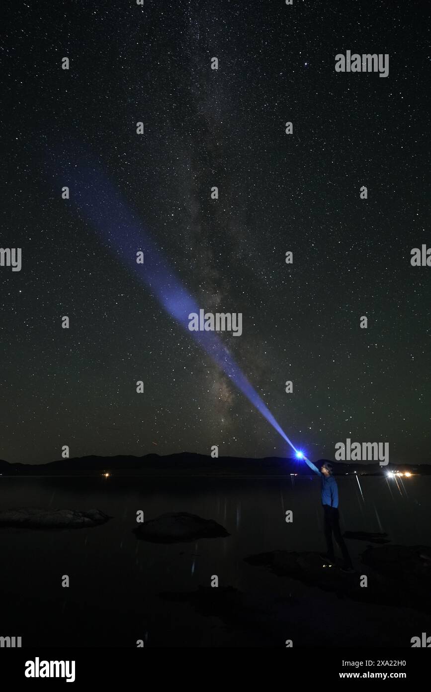Man standing in lake with flashlight beams underwater Stock Photo - Alamy