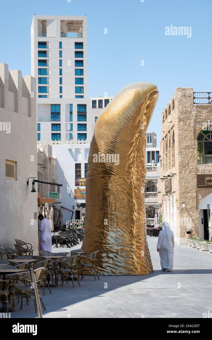 A pedestrian in motion by a grand gold statue on a city street Stock ...