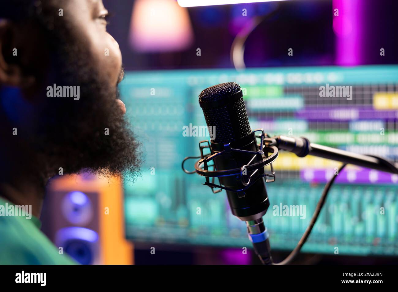 Male composer recording his melody on microphone in home studio, singing a song of his own ...