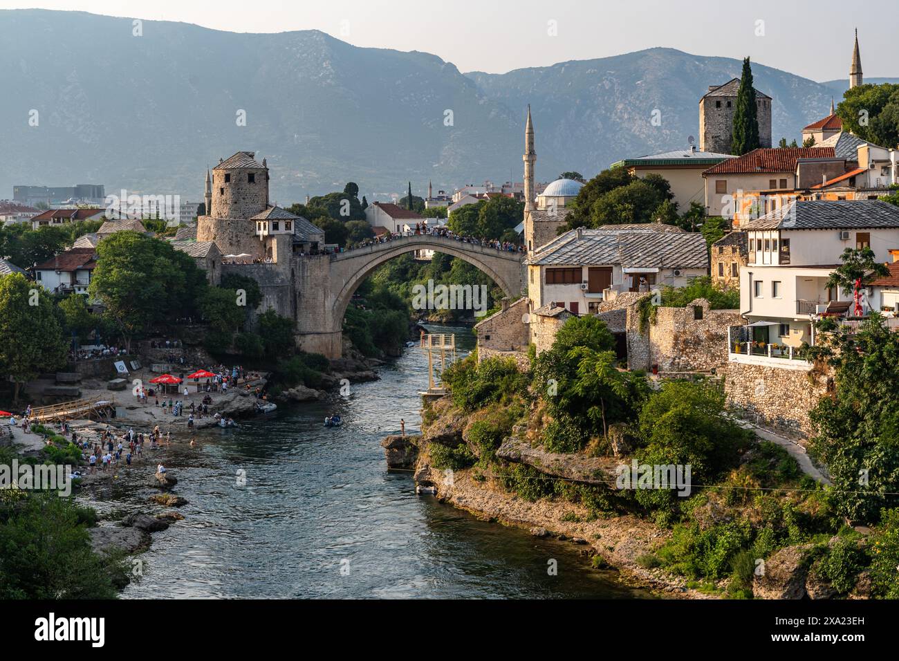 This photo captures a river running through Mostar city, with a ...
