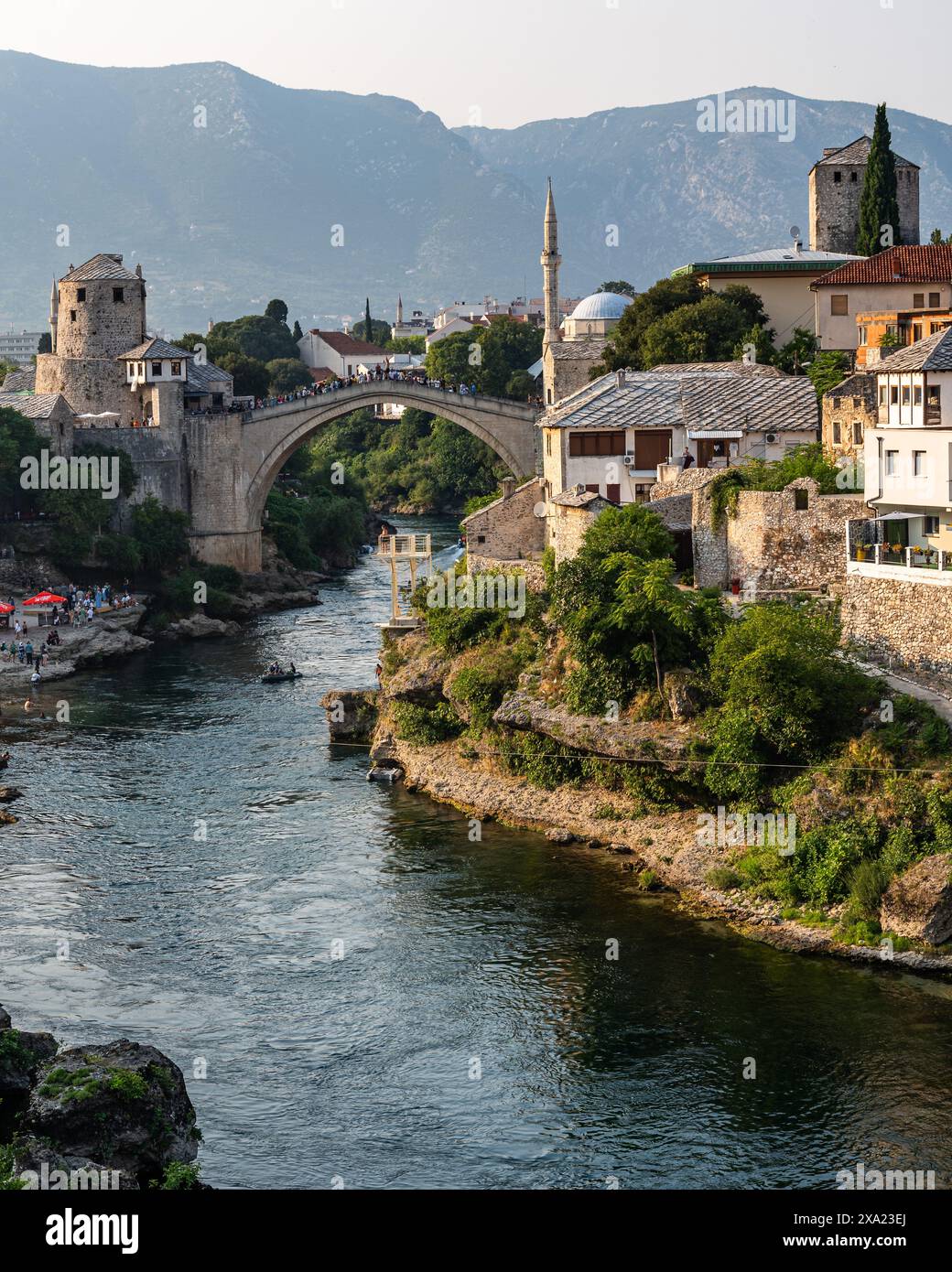 This photo captures a river running through Mostar city, with a ...