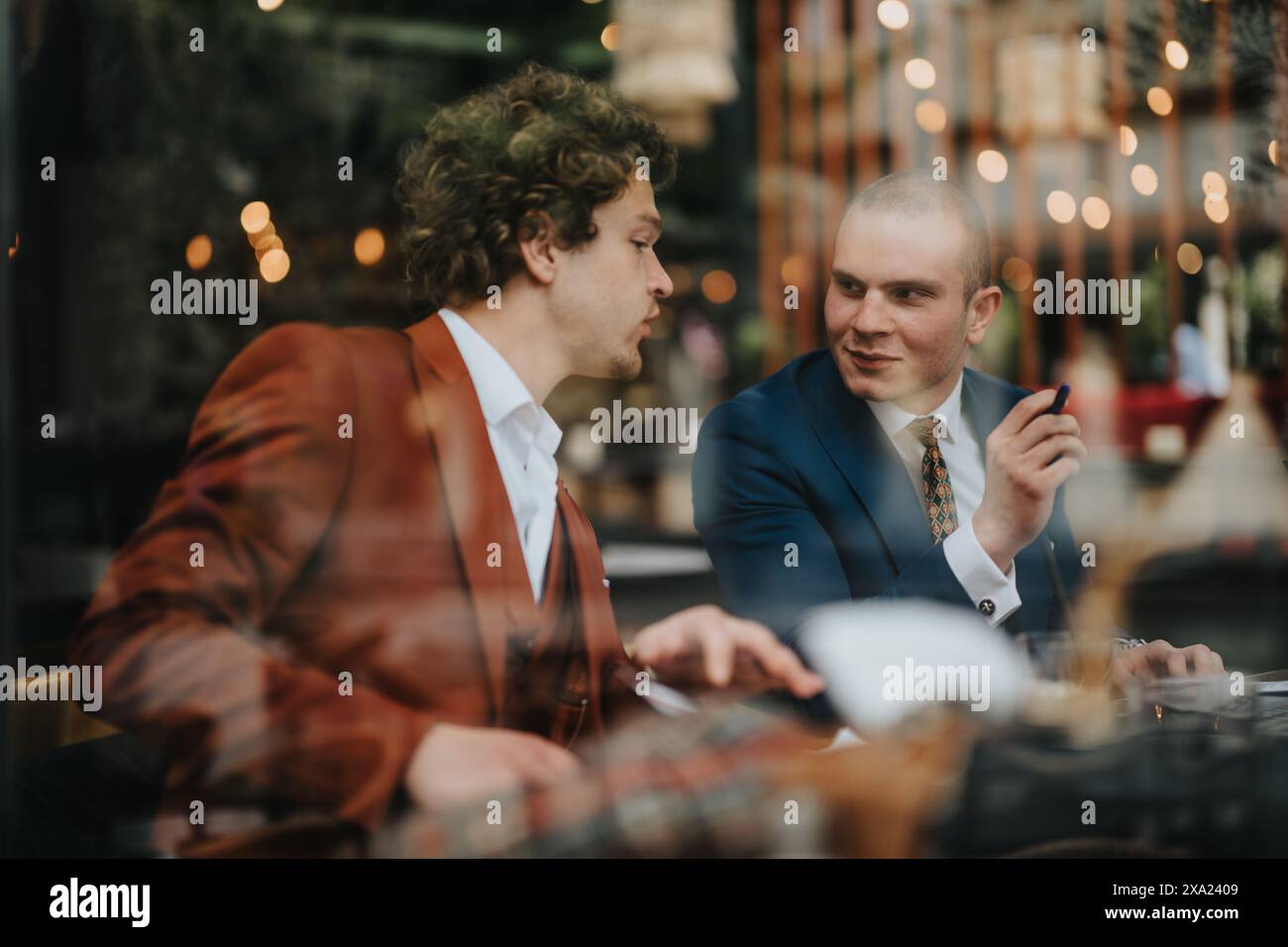 Businessmen having a discussion over lunch in a modern restaurant ...