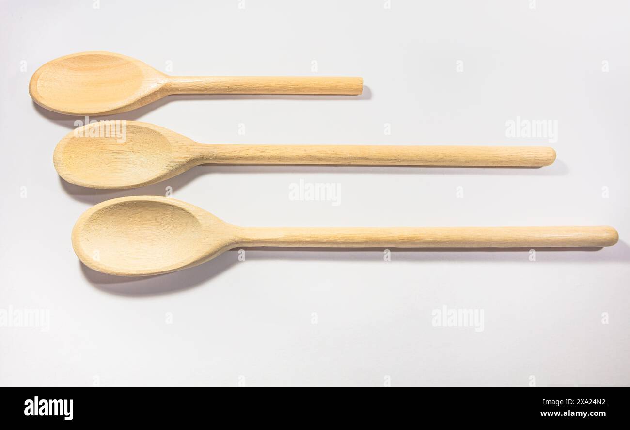 Three wooden spoons lined up on white background Stock Photo - Alamy