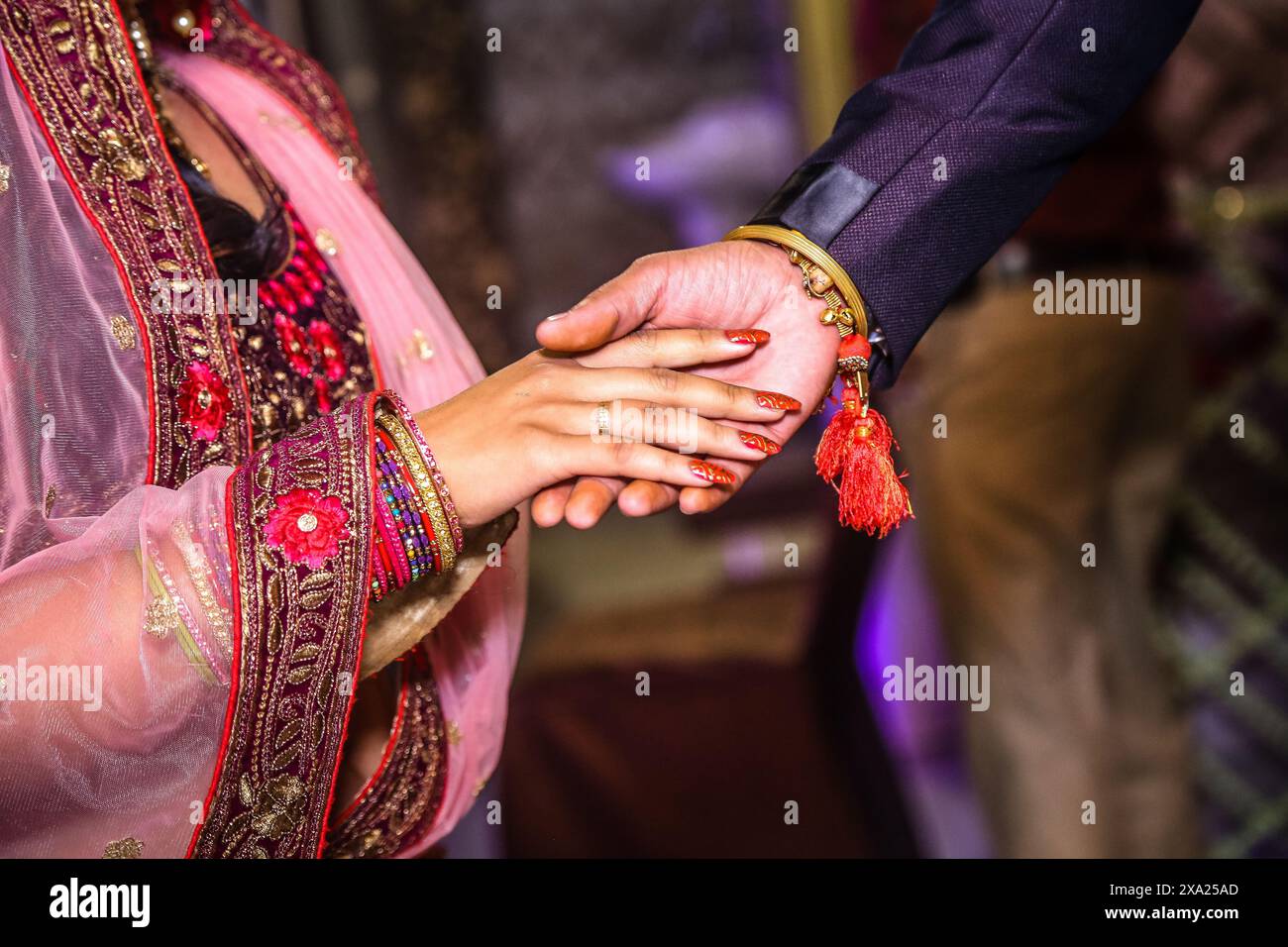 A couple in traditional attire clasps hands Stock Photo - Alamy