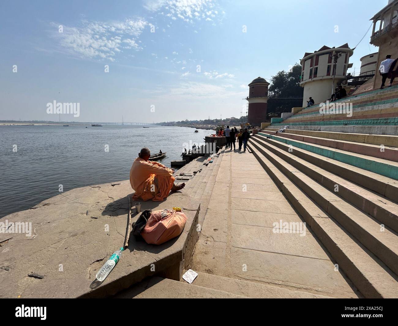 Some people relaxing on beach near water with a staircase in India ...